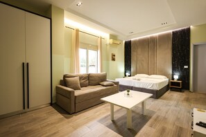 Quarto moderno com sofá, cama, mesa de cabeceira e guarda-roupa.