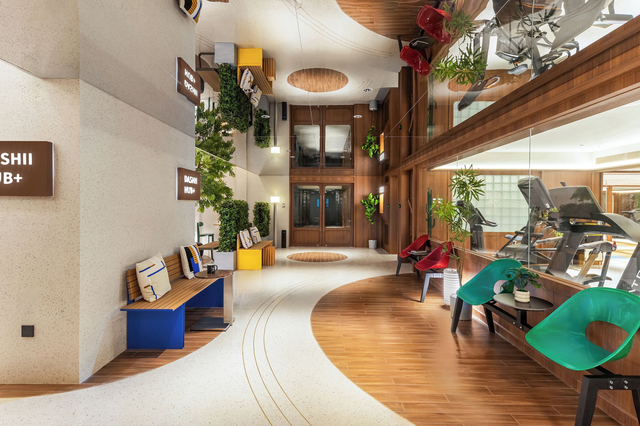 Um interior moderno com balcão de recepção, área de estar e equipamentos de ginástica.