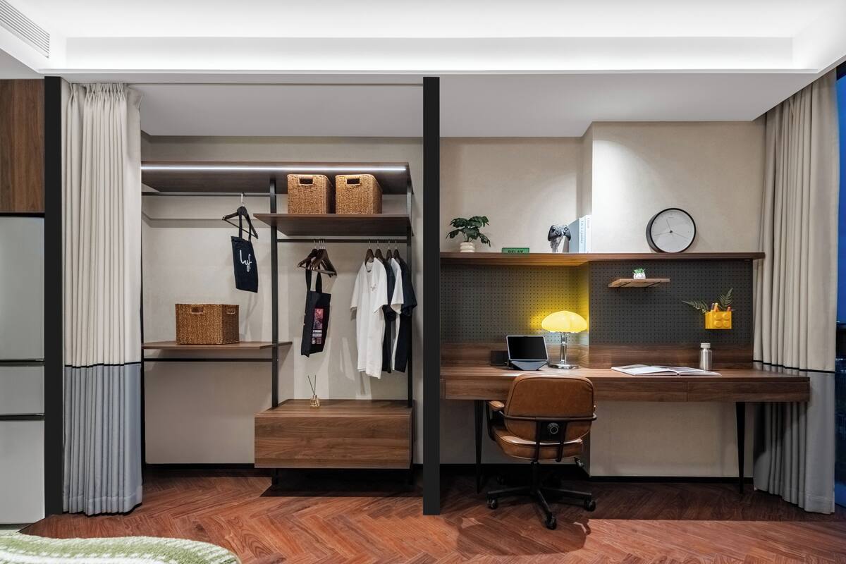 Quarto moderno com escrivaninha embutida, guarda-roupa e cama.