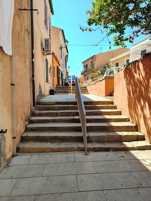 Uma rua estreita com degraus de pedra que levam a um edifício com varanda.