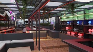Uma área de bar moderna com assentos, um alvo de dardos e prateleiras com garrafas.