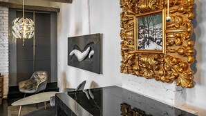 Um interior moderno com bancada de mármore, moldura dourada ornamentada e uma pintura abstrata única.
