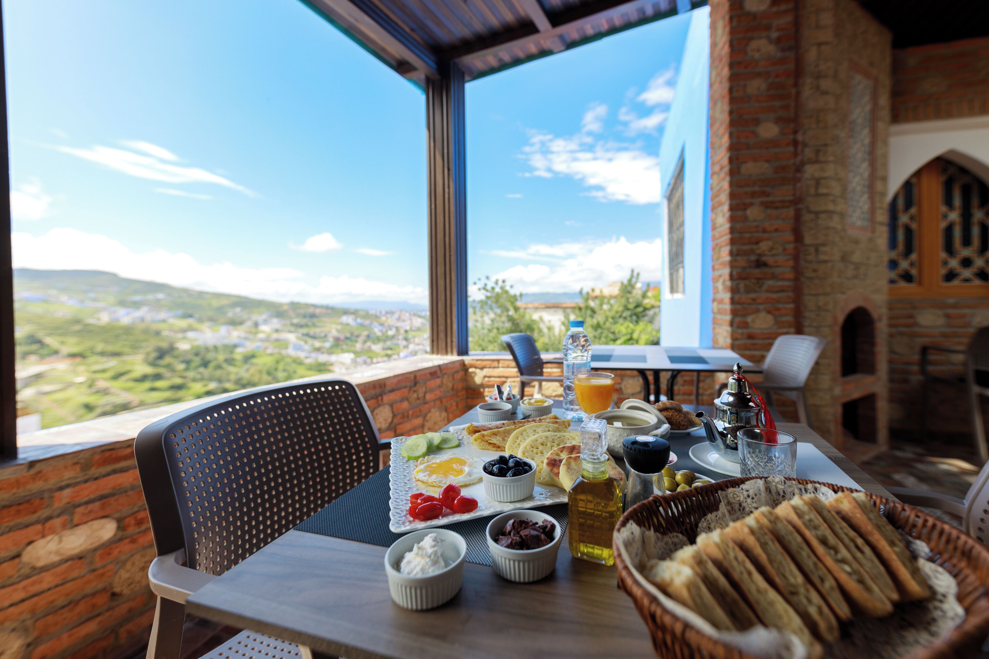 Mesa posta para o café da manhã, com vista para o campo.