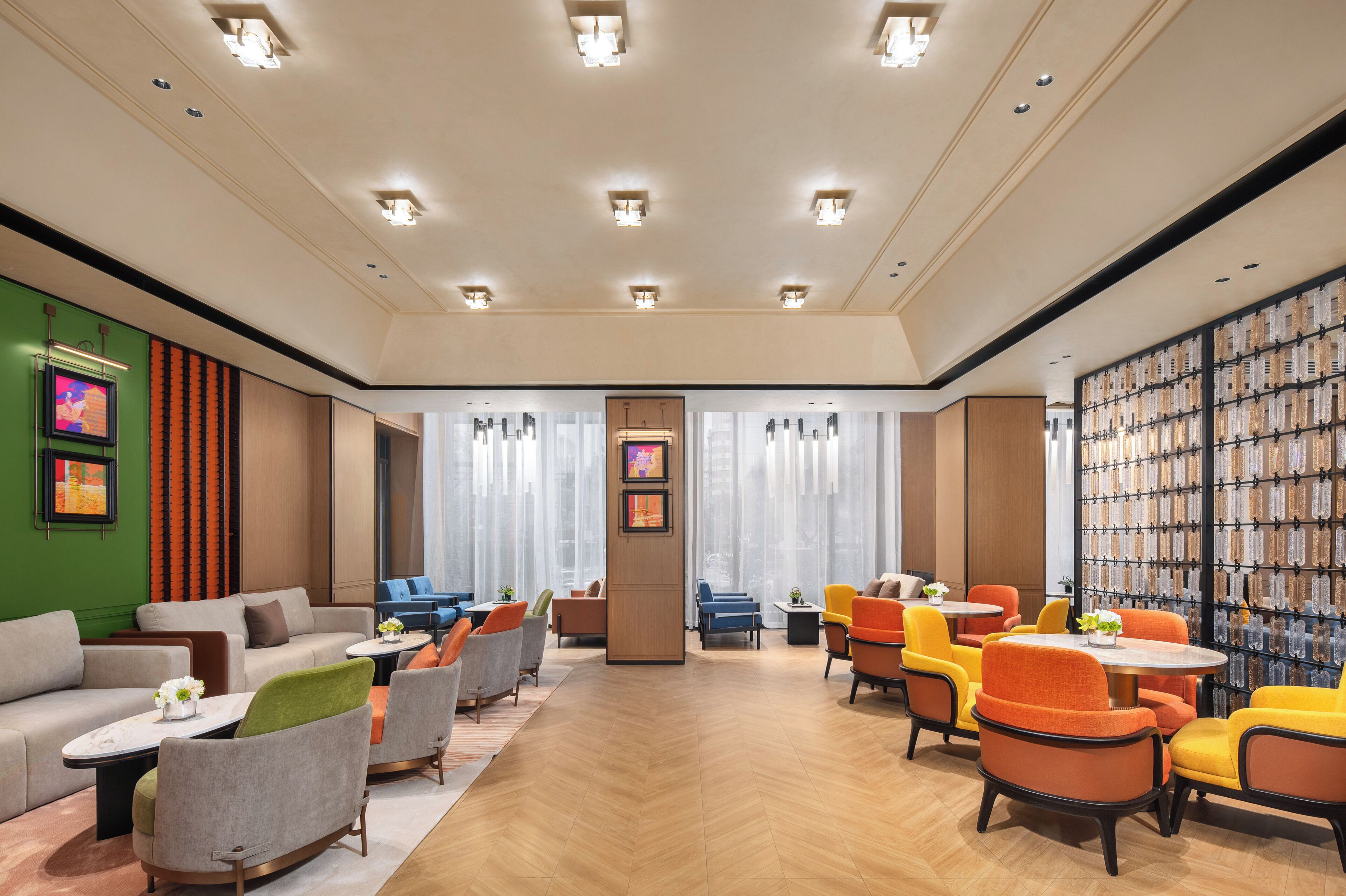Um hall amplo com design moderno, com diferentes áreas de estar e uma parede repleta de estantes.
