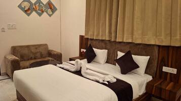 Quarto de hotel com cama, sofá, cabeceira de madeira e obra de arte pendurada na parede.
