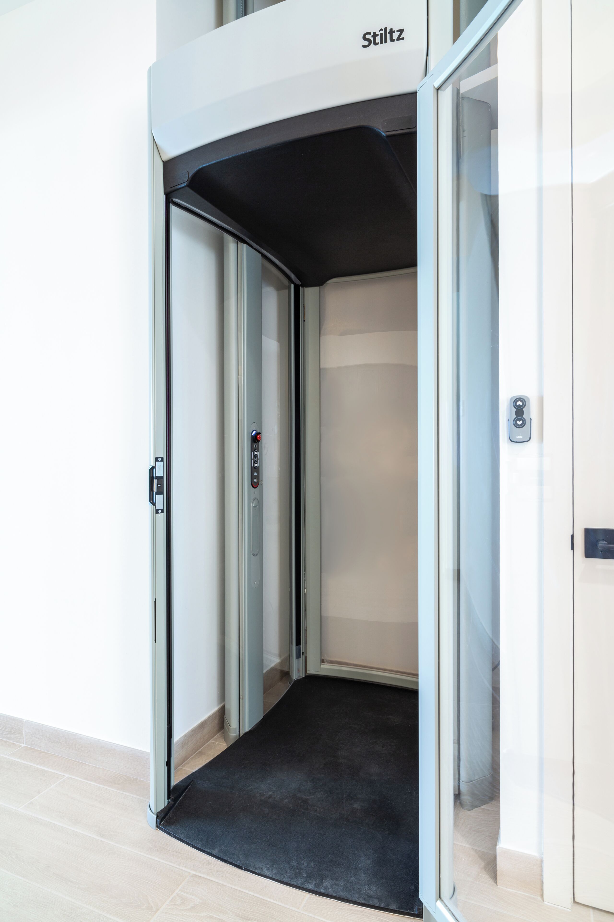 Um elevador moderno com porta de vidro e painel de controle.