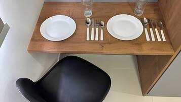 Uma mesa de jantar com dois pratos brancos, talheres e copos.