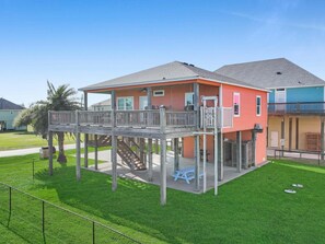 Uma casa de dois andares com varanda, alpendre coberto e um pequeno deck.