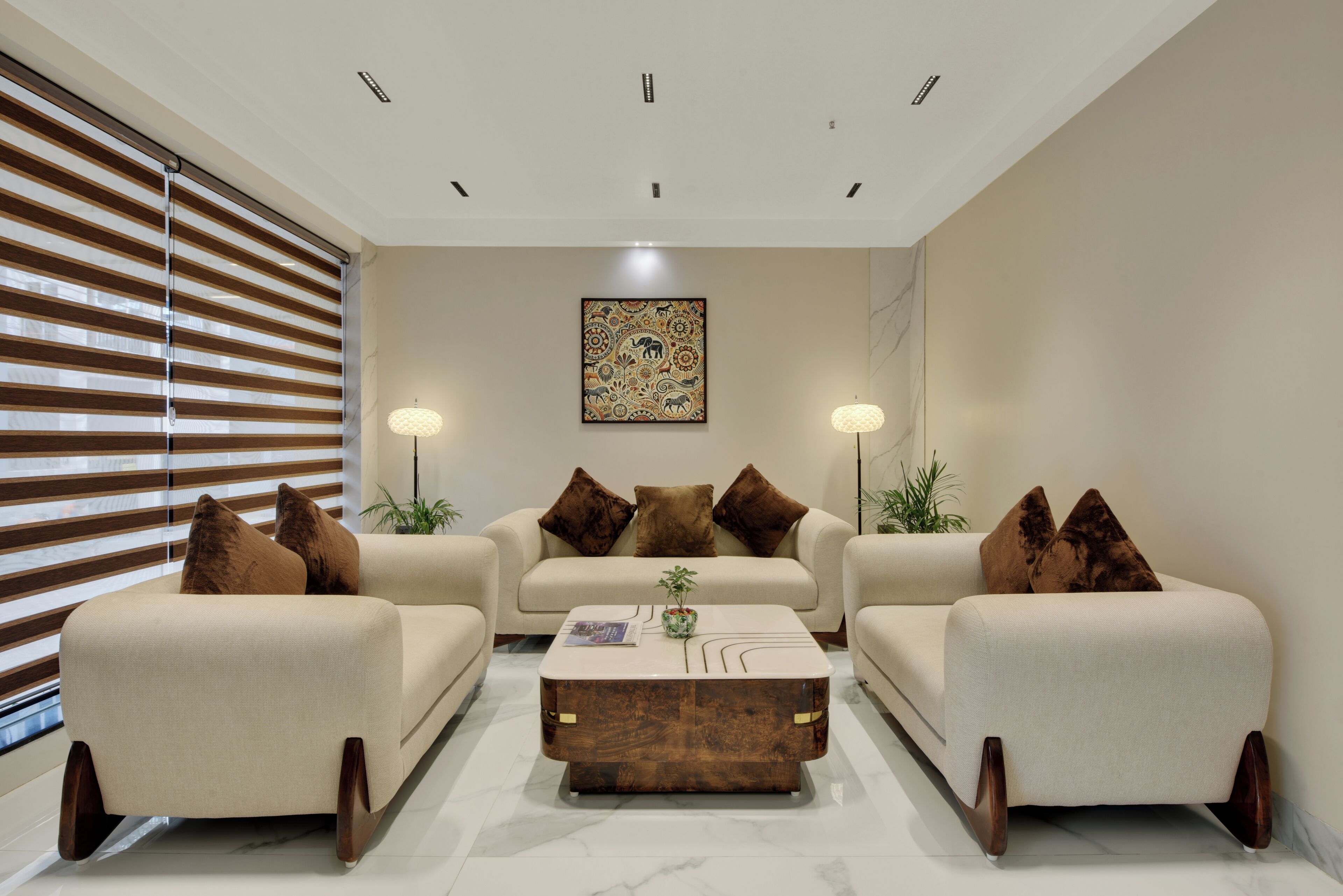 Uma sala de estar moderna com um sofá, uma mesa de centro e luminárias decorativas.