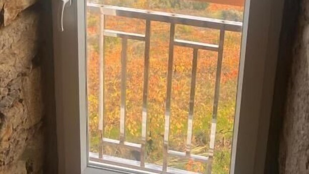 Uma porta com vista para um rio e paisagem circundante.
