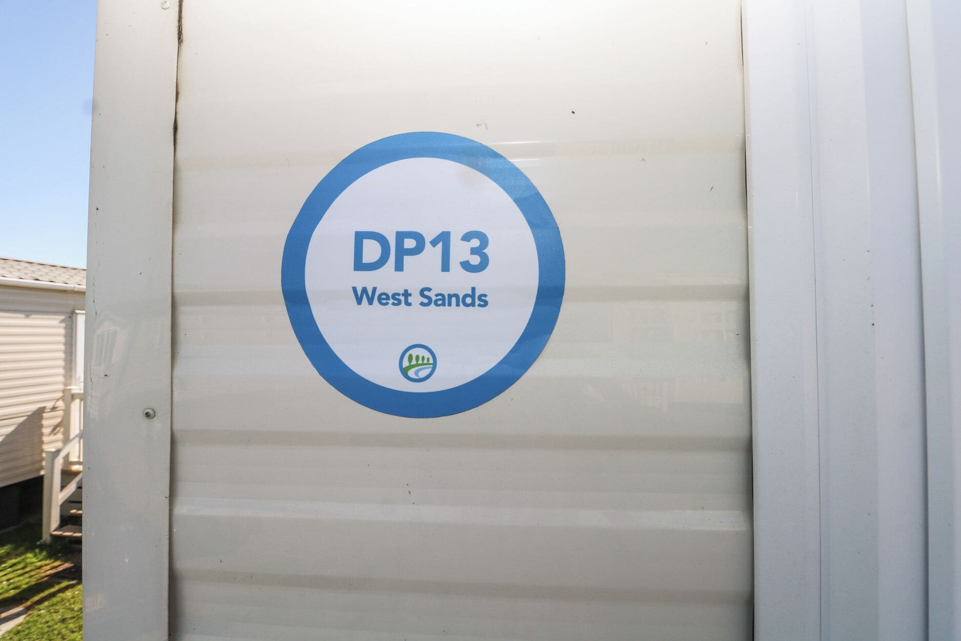 Uma placa com 'DP13 West Sands' e um logótipo.