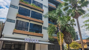 Um hotel com fachada moderna, várias varandas e uma placa indicando que se trata de um hotel.