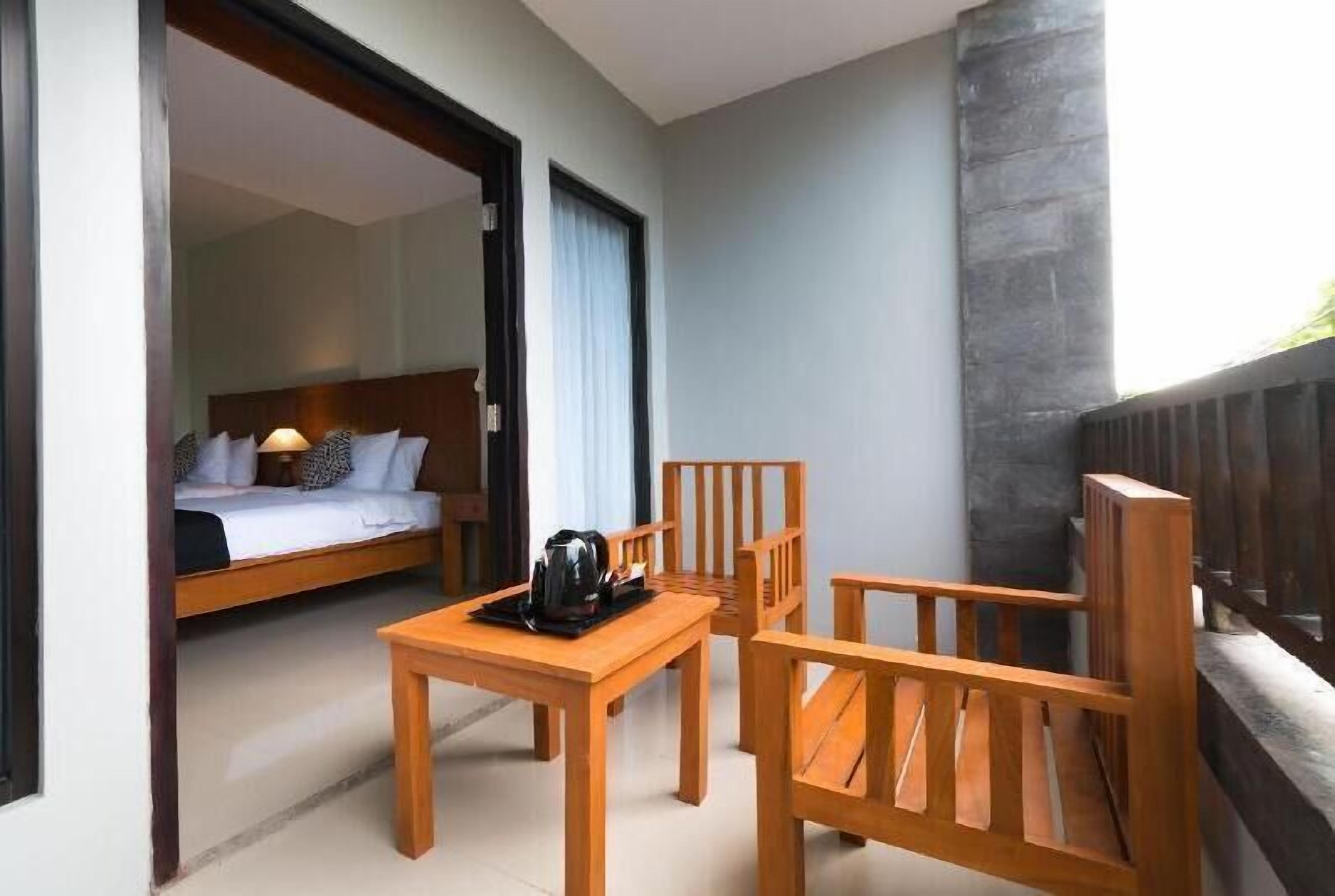 Varanda com cama, mobiliário de madeira e parede de pedra.