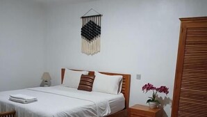 Um quarto com cama, mesas de cabeceira, tapete e guarda-roupa.