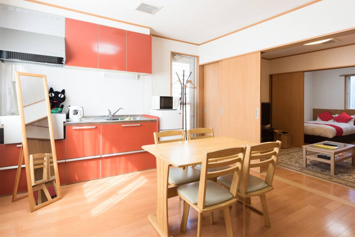 Um espaço compacto com cozinha, área de refeições e quarto.