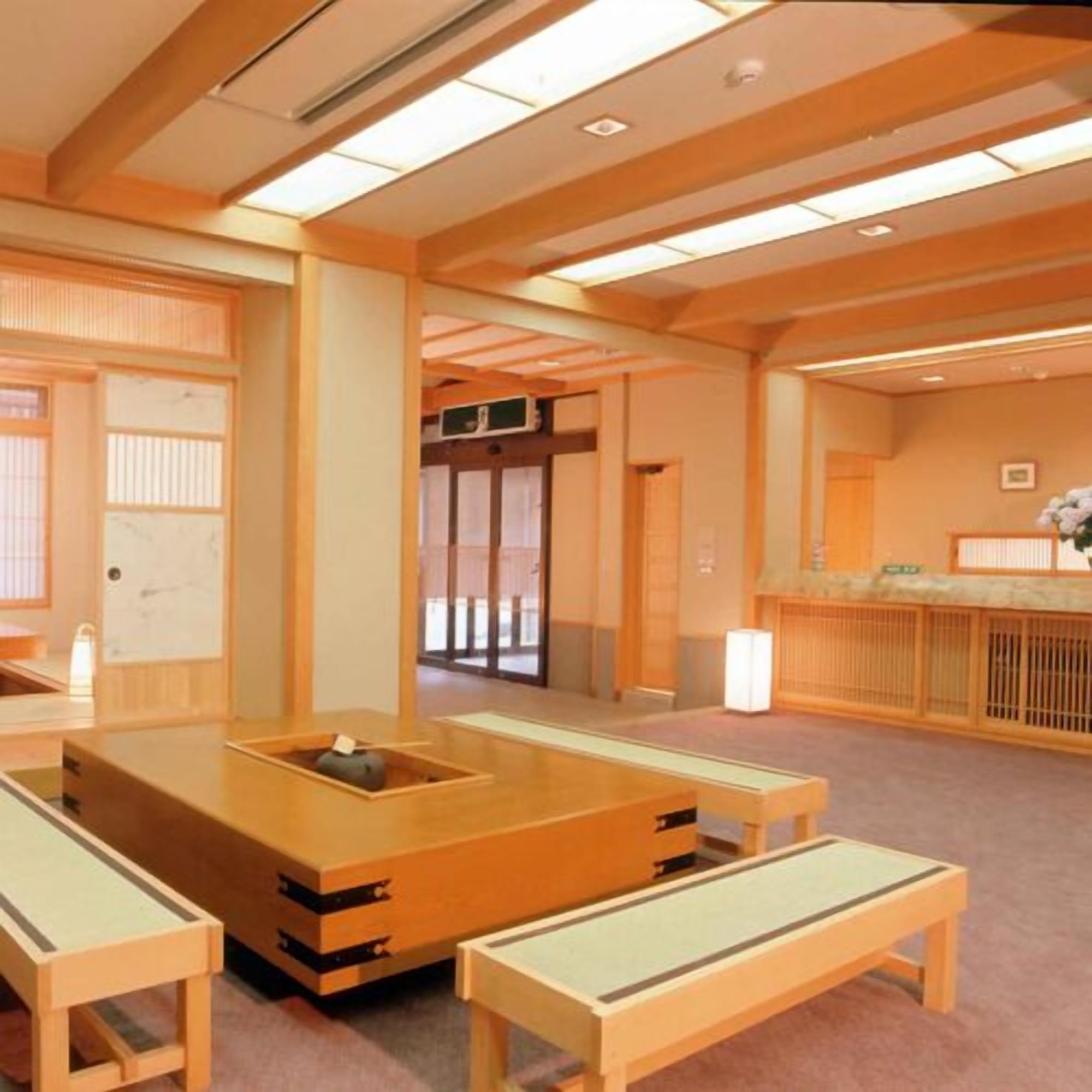 Um quarto tradicional japonês, com tatames, mesinhas baixas e portas deslizantes.
