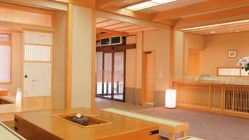 Um quarto tradicional japonês, com tatames, mesinhas baixas e portas deslizantes.