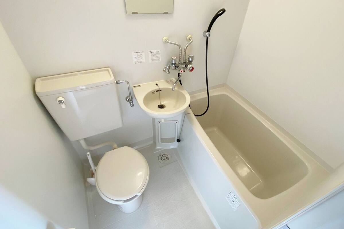 Um banheiro pequeno com vaso sanitário, pia e banheira.