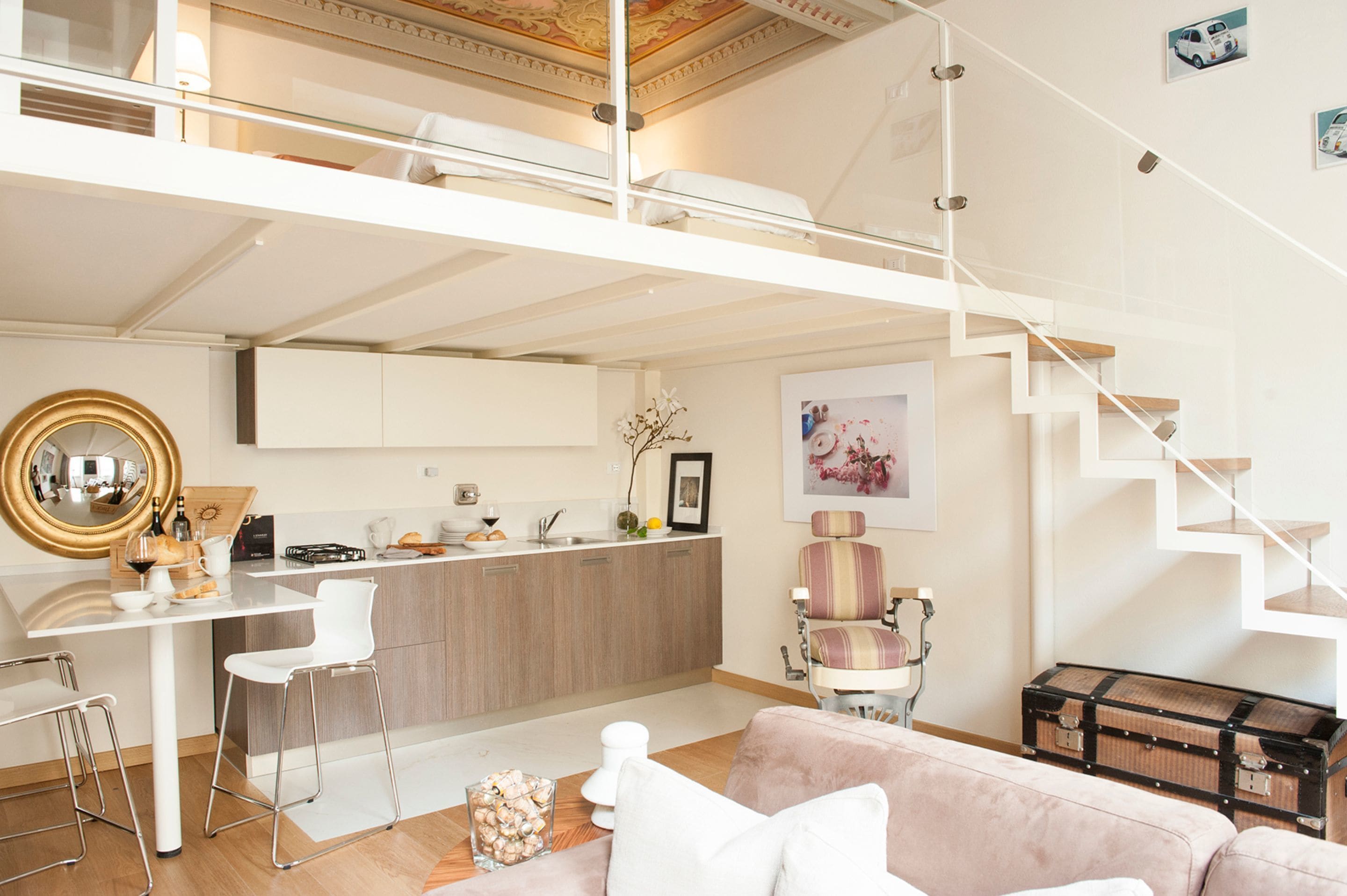 Um espaço de estar moderno em estilo loft, com cozinha, área de jantar e escada.