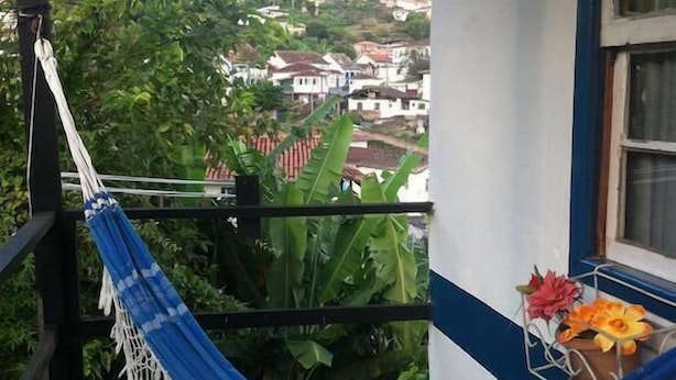 Uma rede numa varanda com vista para uma vila numa colina.