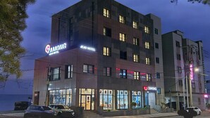 Um hotel de vários andares com design moderno, apresentando uma placa grande com a inscrição 'ZAMONG' na fachada.