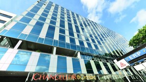 Um edifício moderno com fachada de vidro e uma placa com a inscrição 'Chancellor Orchard'.