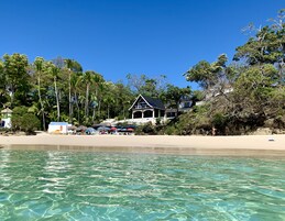 Na praia, espreguiçadeiras, guarda-sóis de praia, toalhas de praia 