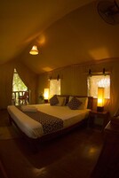 Quarto espaçoso com uma cama grande, duas luminárias de cabeceira e vista para o exterior.