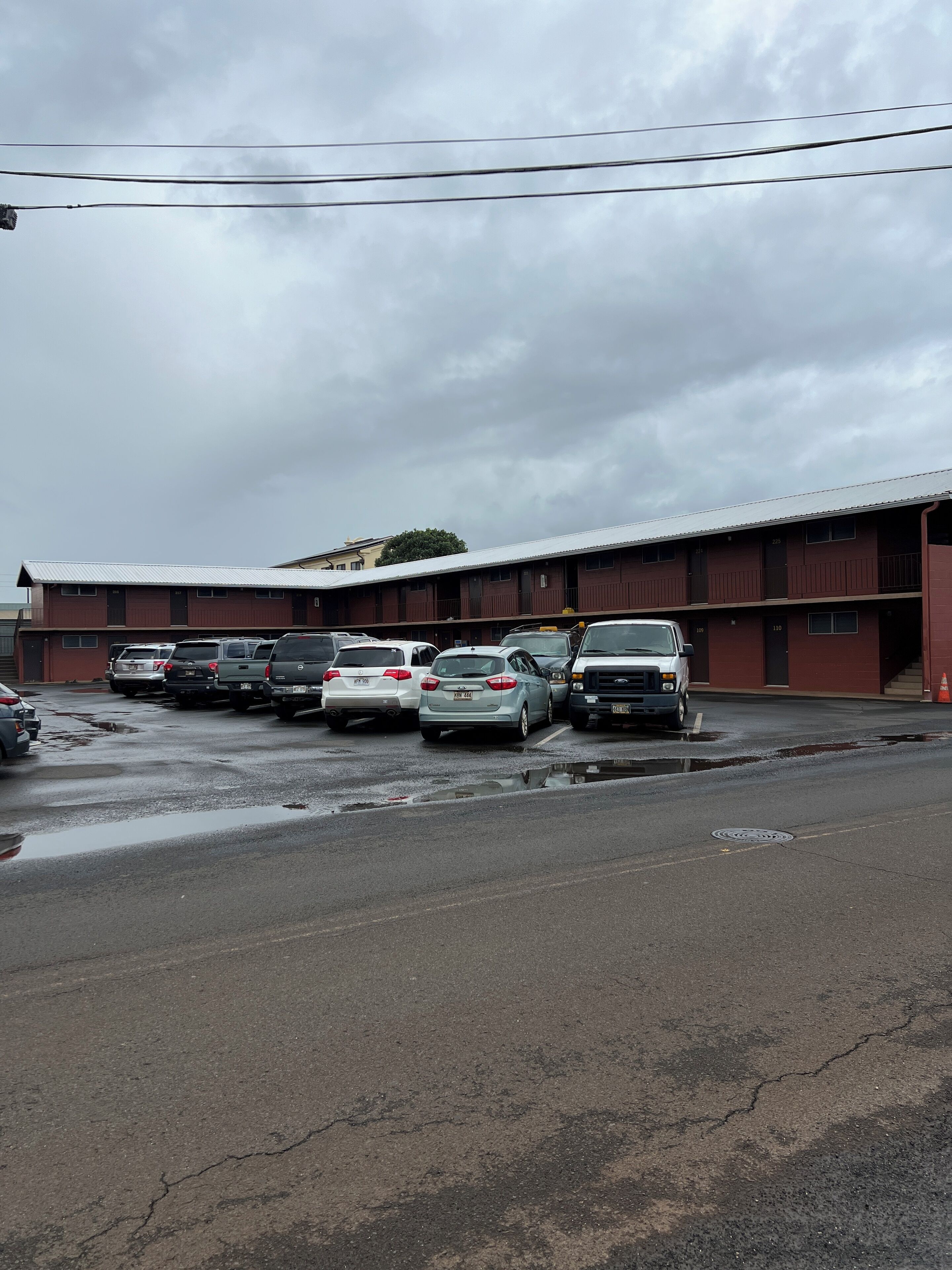 Um motel de vários andares com fachada vermelha e telhado plano.