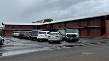 Um motel de vários andares com fachada vermelha e telhado plano.
