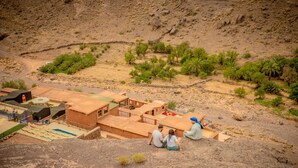Maquete de uma vila no deserto, com edifícios tradicionais, uma pequena mesquita e uma estrada.