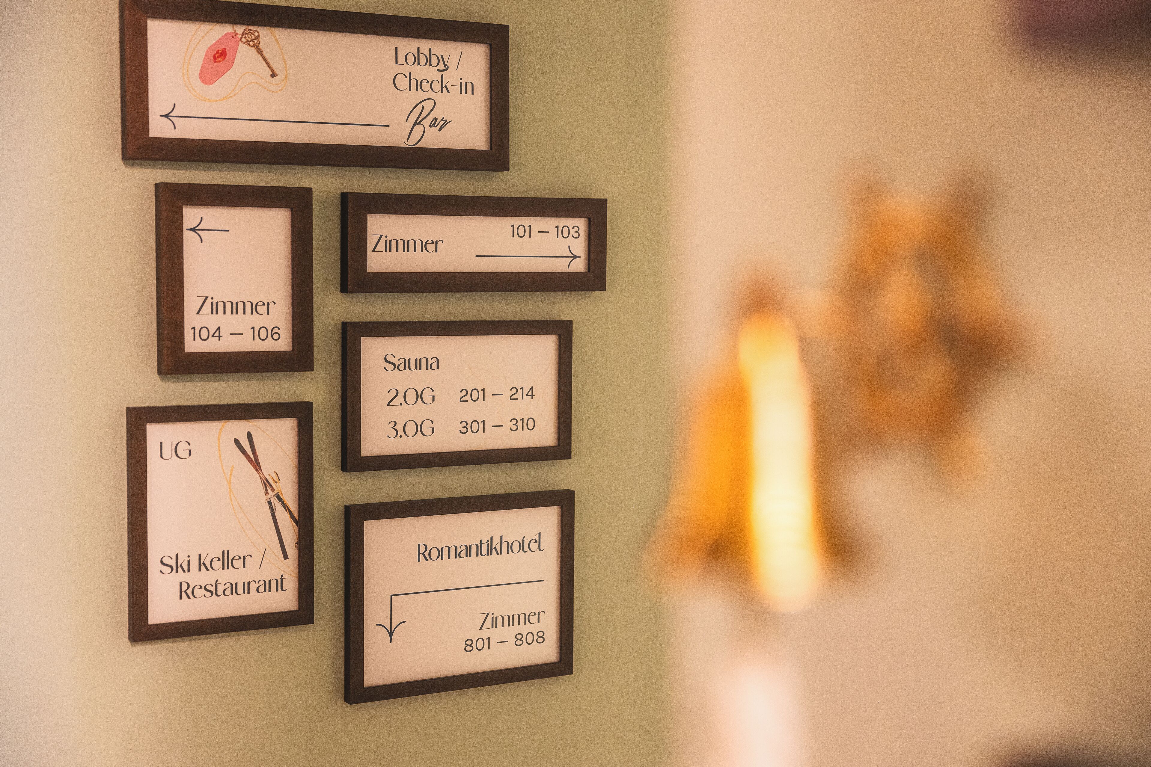 Placas indicam números de quartos e comodidades como saguão, bar de check-in, restaurante de esqui, sauna e um hotel romântico.