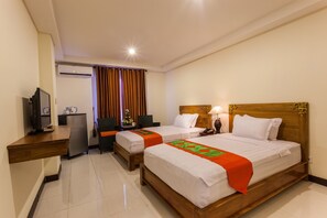 Quarto de hotel com duas camas, uma mesa, televisão e uma pequena copa.