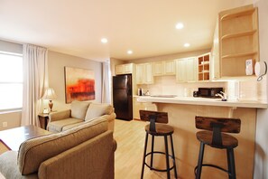 Suíte luxo, 1 cama Queen, cozinha | Área de estar | TV de tela plana