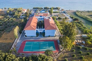 Um imóvel à beira-mar com quadra de tênis, piscina e vista para a praia.