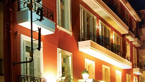 Um edifício de vários andares com varandas, janelas amplas e iluminação externa acolhedora.