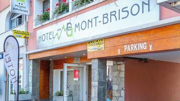 Um hotel chamado "HOTEL MONT-BRISON" com uma placa indicando estacionamento.