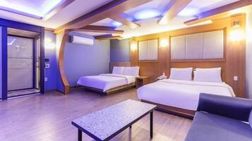 Quarto de hotel com duas camas, uma mesinha e estrutura de teto em madeira.