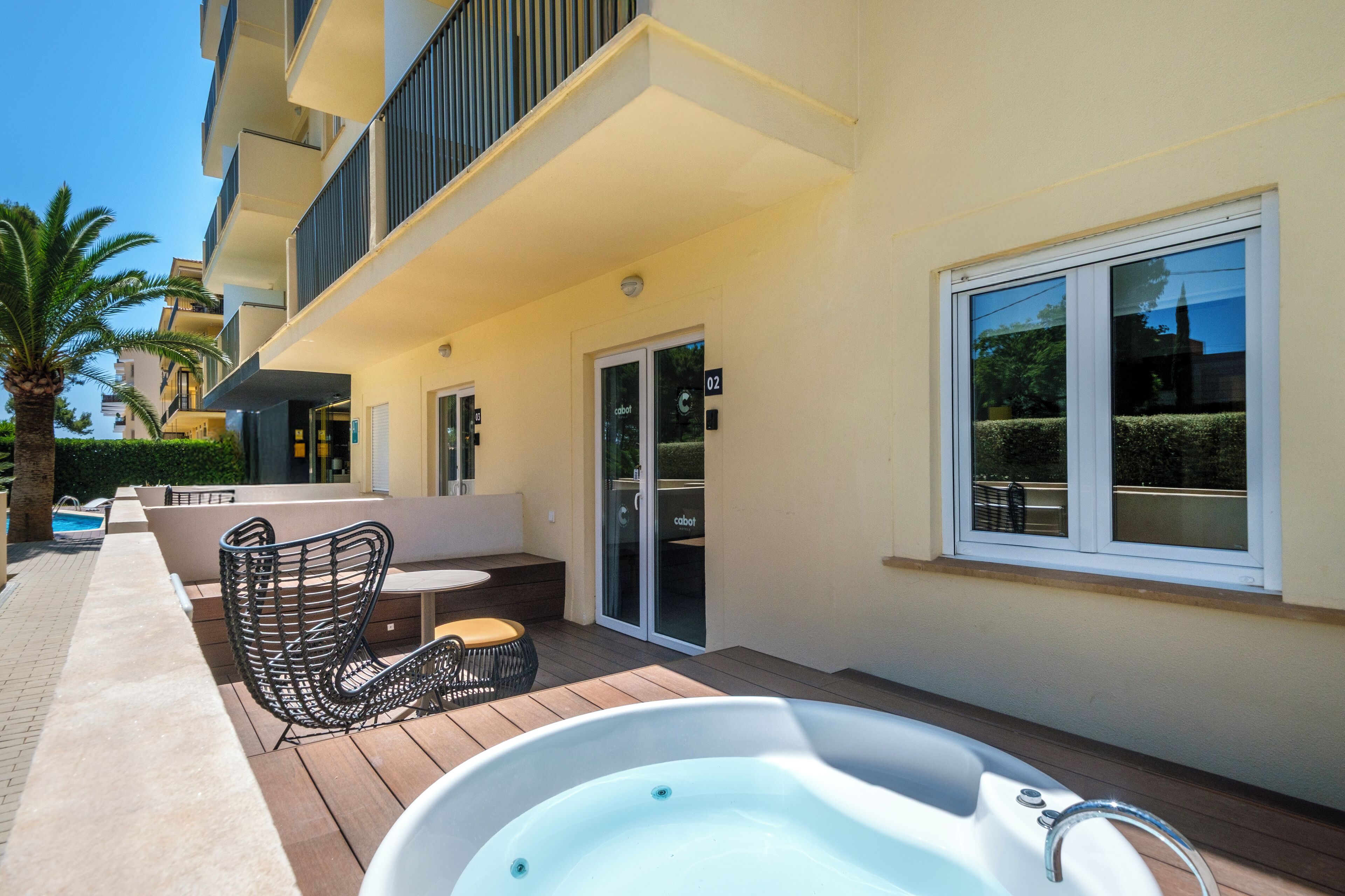 Uma área externa moderna com hidromassagem, assentos e piscina.