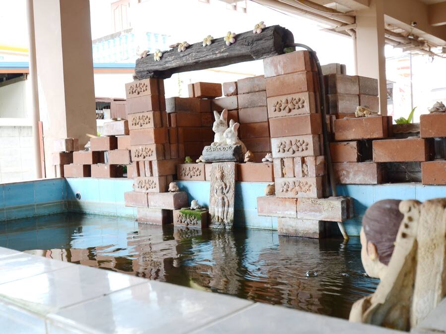 Piscina com estrutura de tijolos e estátua de um coelho.