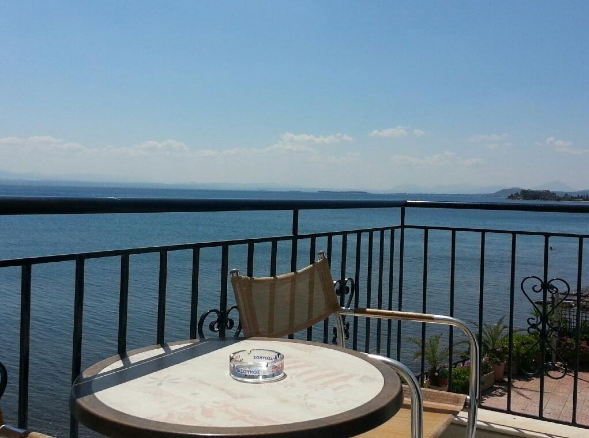 Varanda com mesa e cadeira com vista para um corpo de água.