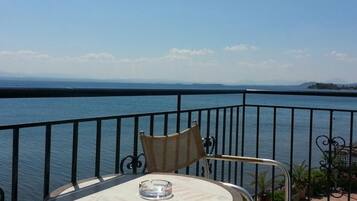 Varanda com mesa e cadeira com vista para um corpo de água.