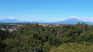 Paisagem montanhosa com um pico nevado imponente ao longe.
