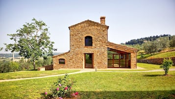 Uma casa de pedra com uma janela grande e varanda coberta.