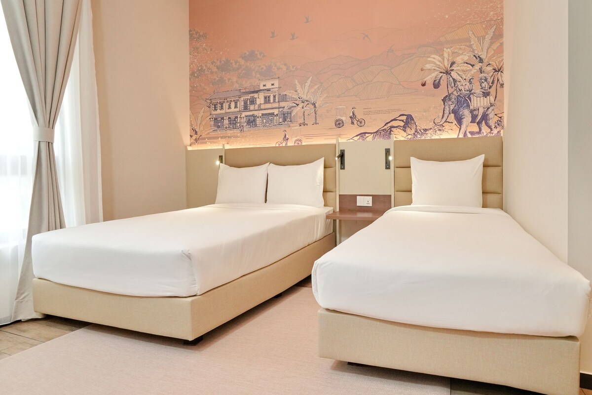 Quarto de hotel com duas camas, um grande mural na parede e uma janela com cortinas.