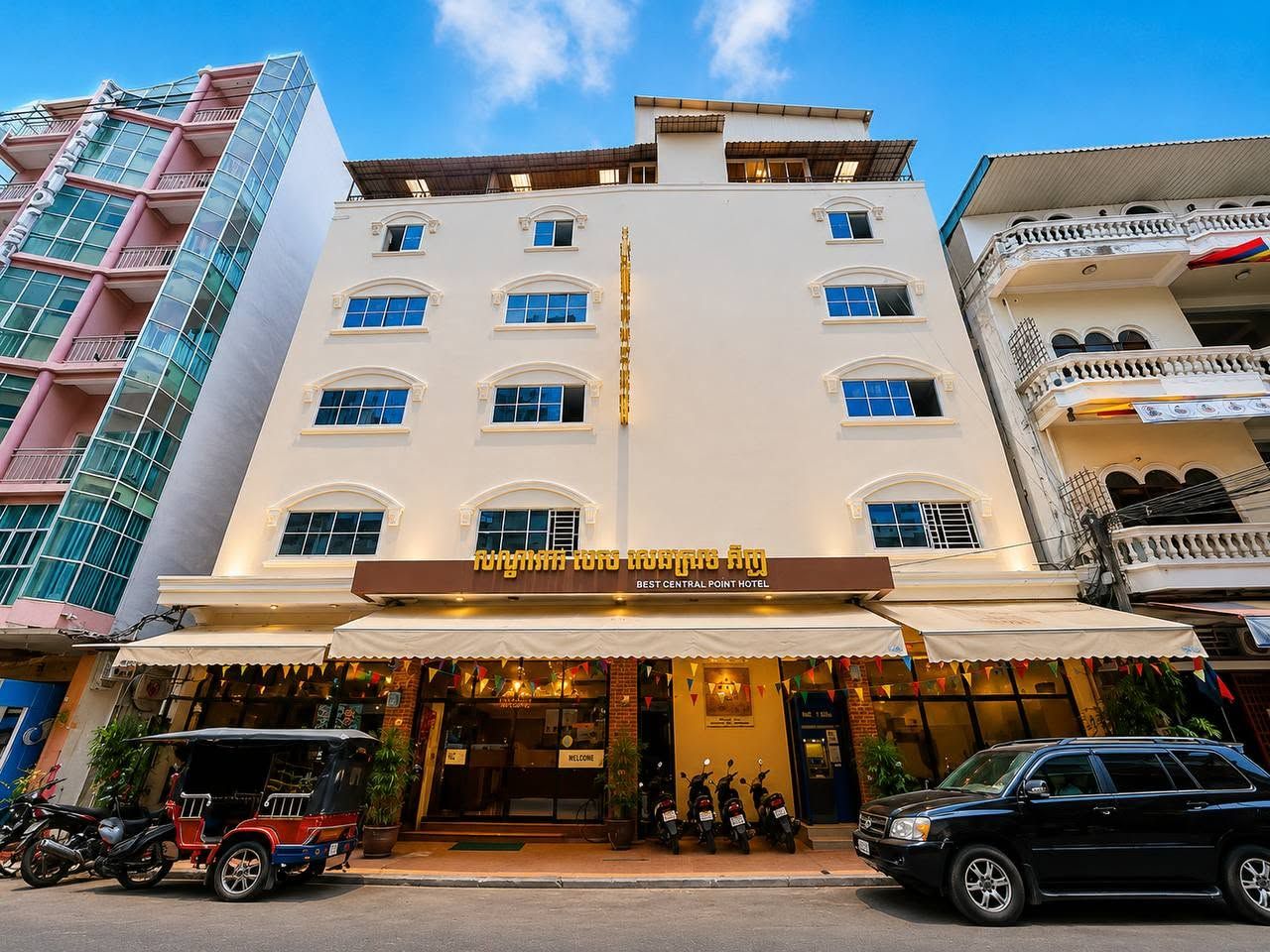 Um hotel com entrada central, várias varandas e céu limpo.