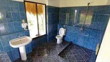 Casa de banho com lavatório, sanita e chuveiro.
