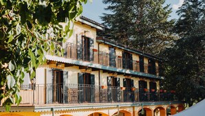 Um edifício de vários andares com varandas, janelas em arco e telhado ladrilhado.