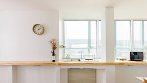 Uma cozinha moderna com bancada de madeira, pia embutida e uma janela ampla com vista para a cidade.