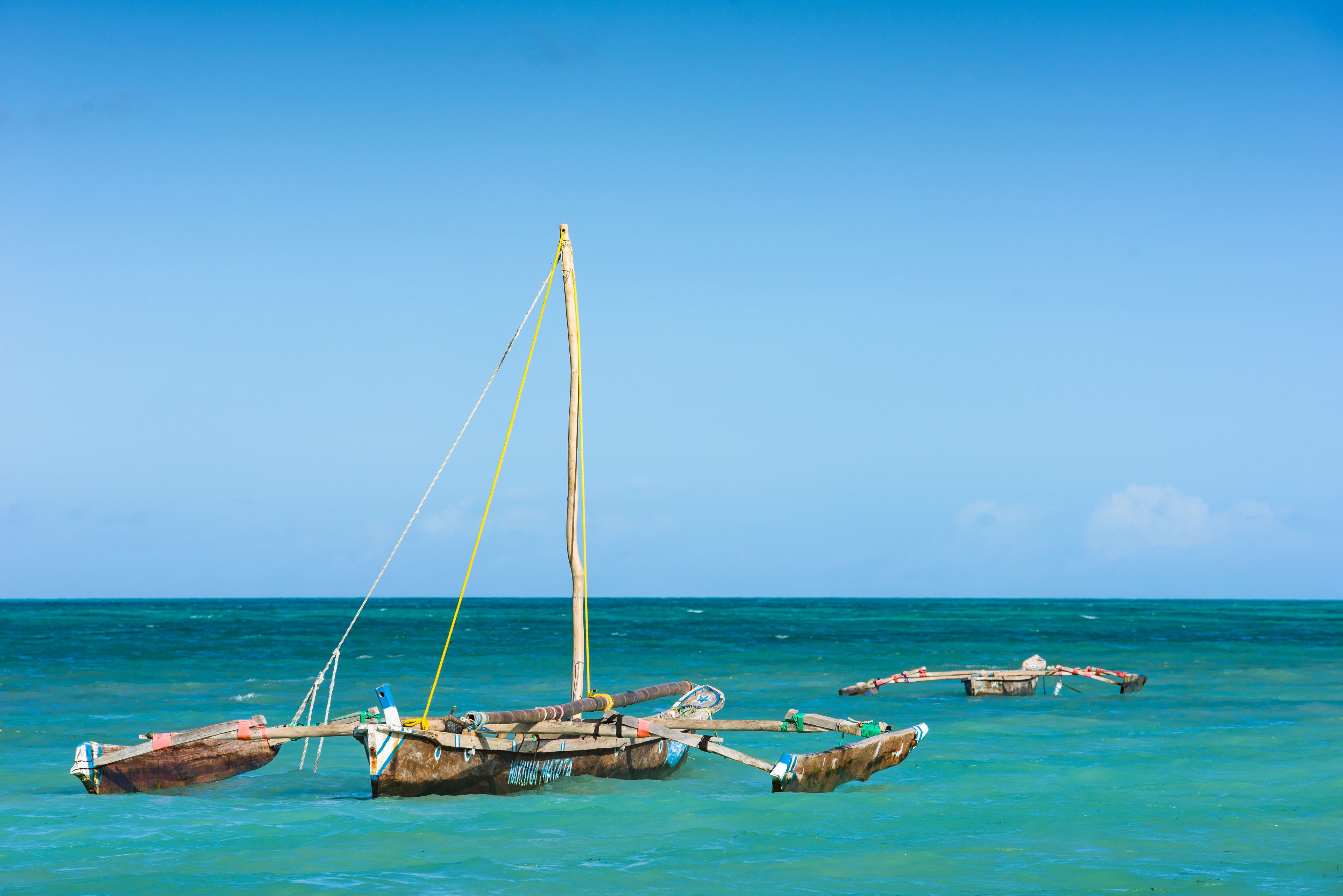 Uma fileira de barcos ancorados em águas calmas.